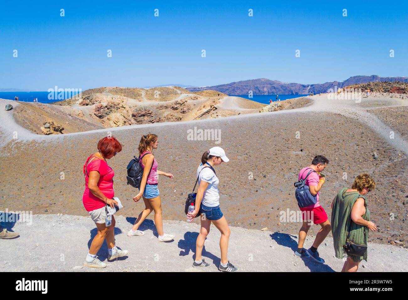 Tourists hiking to the active volcano- highlight of Santorini and ...