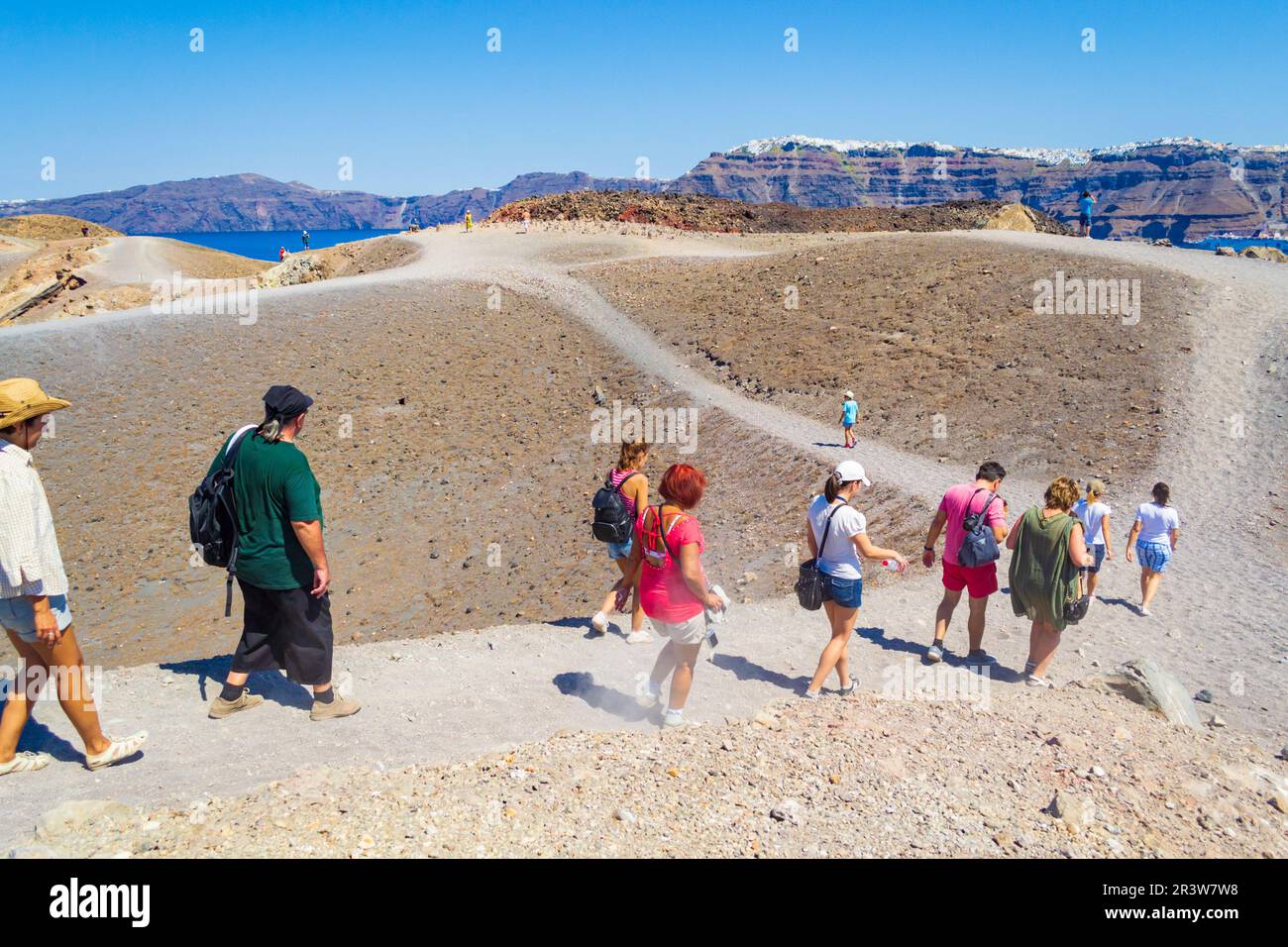 Tourists hiking to the active volcano- highlight of Santorini and ...