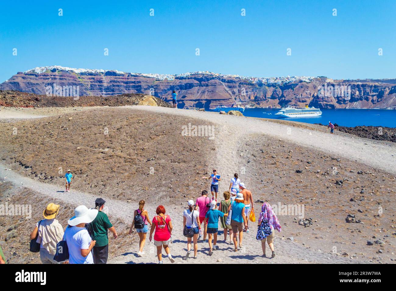 Tourists hiking to the active volcano- highlight of Santorini and ...