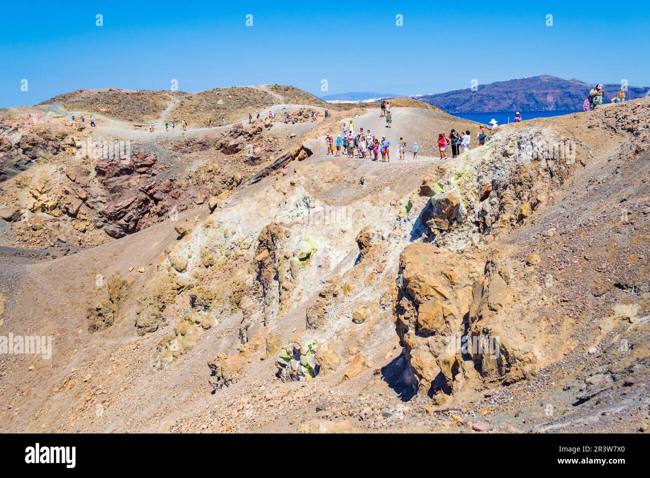 Tourists sightseeing the active volcano- highlight of Santorini and ...