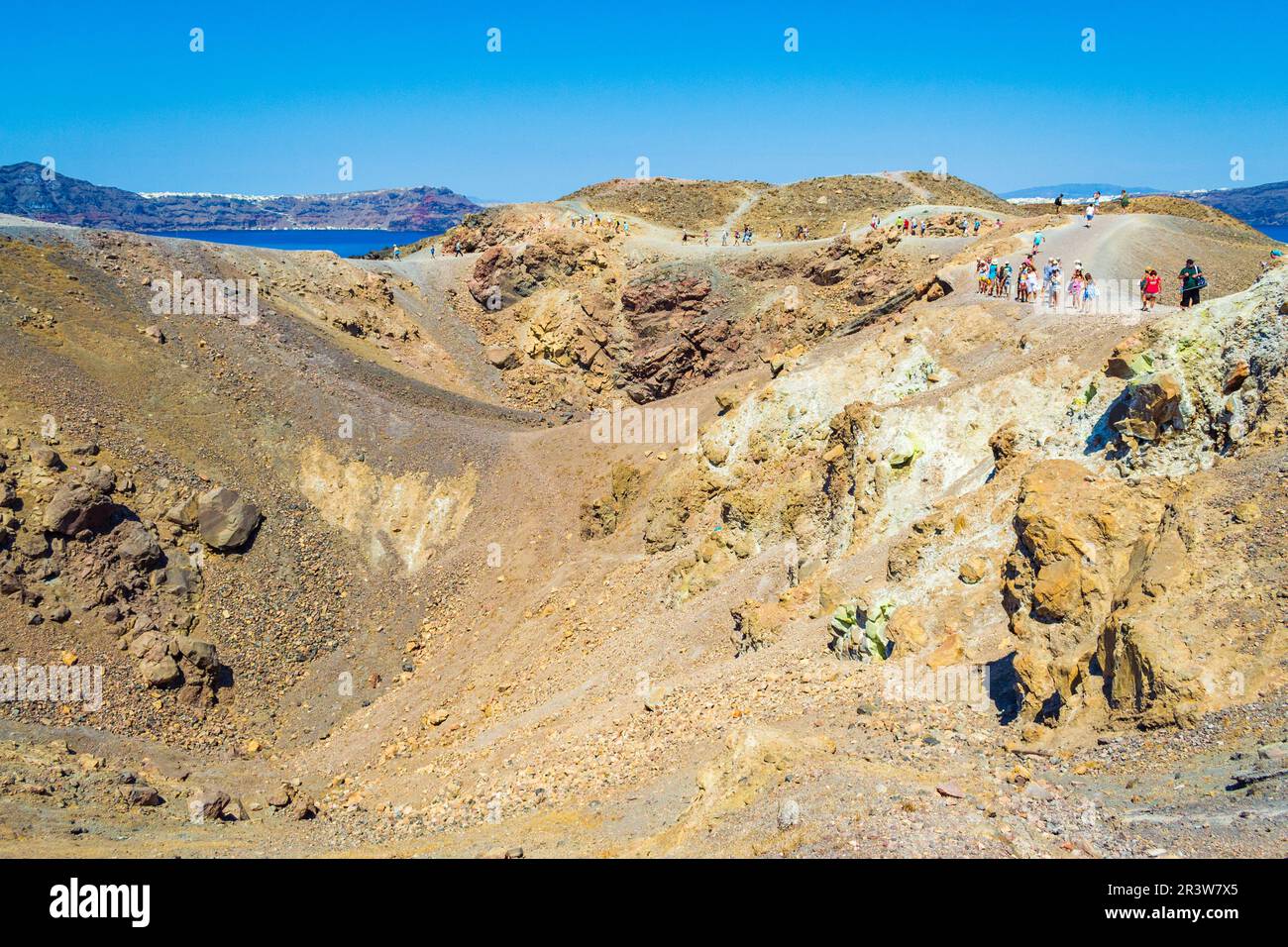Tourists sightseeing the active volcano- highlight of Santorini and ...
