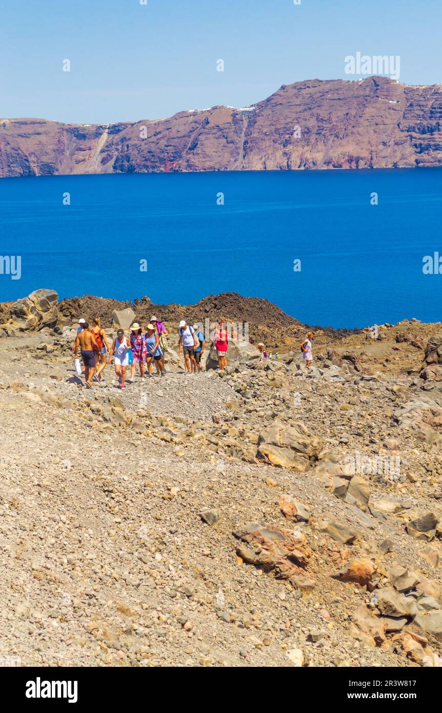 Tourists hiking to the active volcano- highlight of Santorini and ...