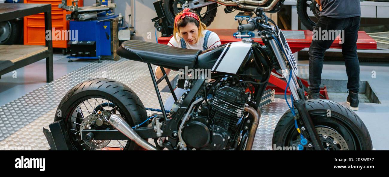 Mechanic checking custom motorcycle on garage Stock Photo - Alamy