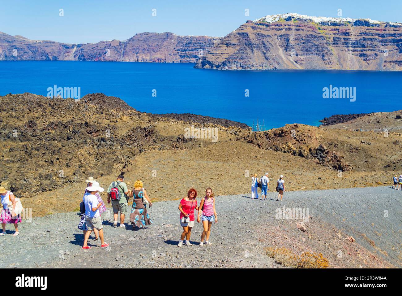Tourists hiking to the active volcano- highlight of Santorini and ...