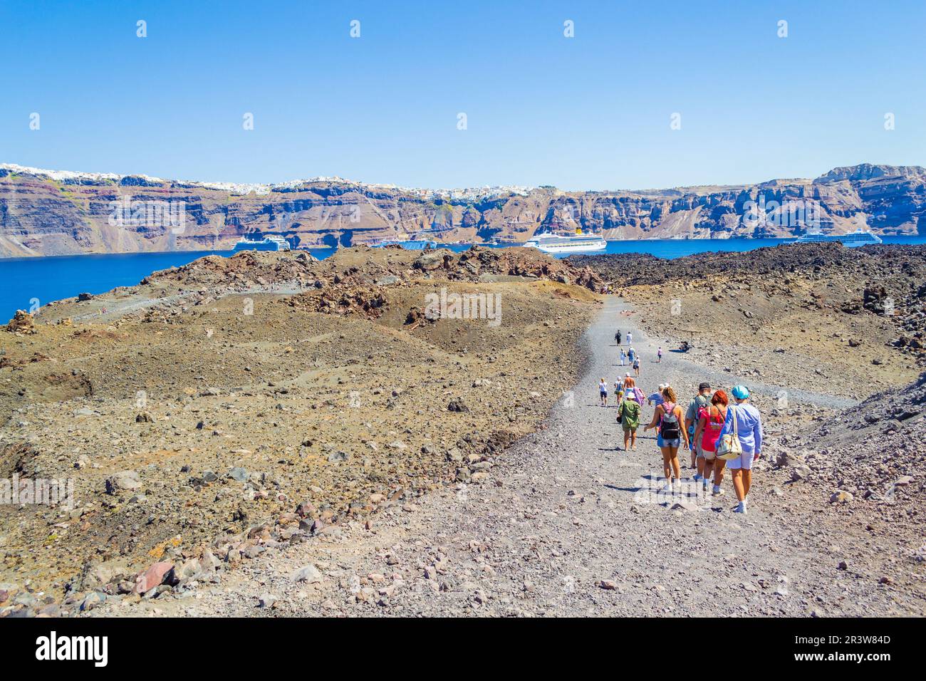 Tourists hiking to the active volcano- highlight of Santorini and ...