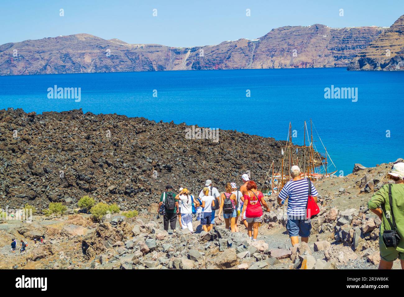 Tourists hiking to the active volcano- highlight of Santorini and ...
