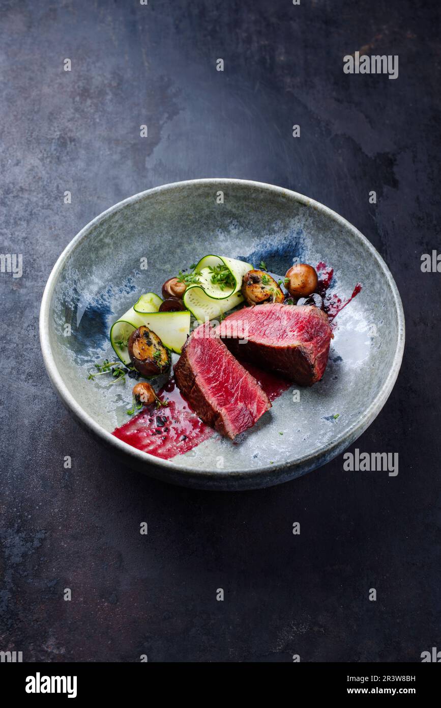 Fried Italian chianina beef fillet steak very rare with mushrooms Stock ...