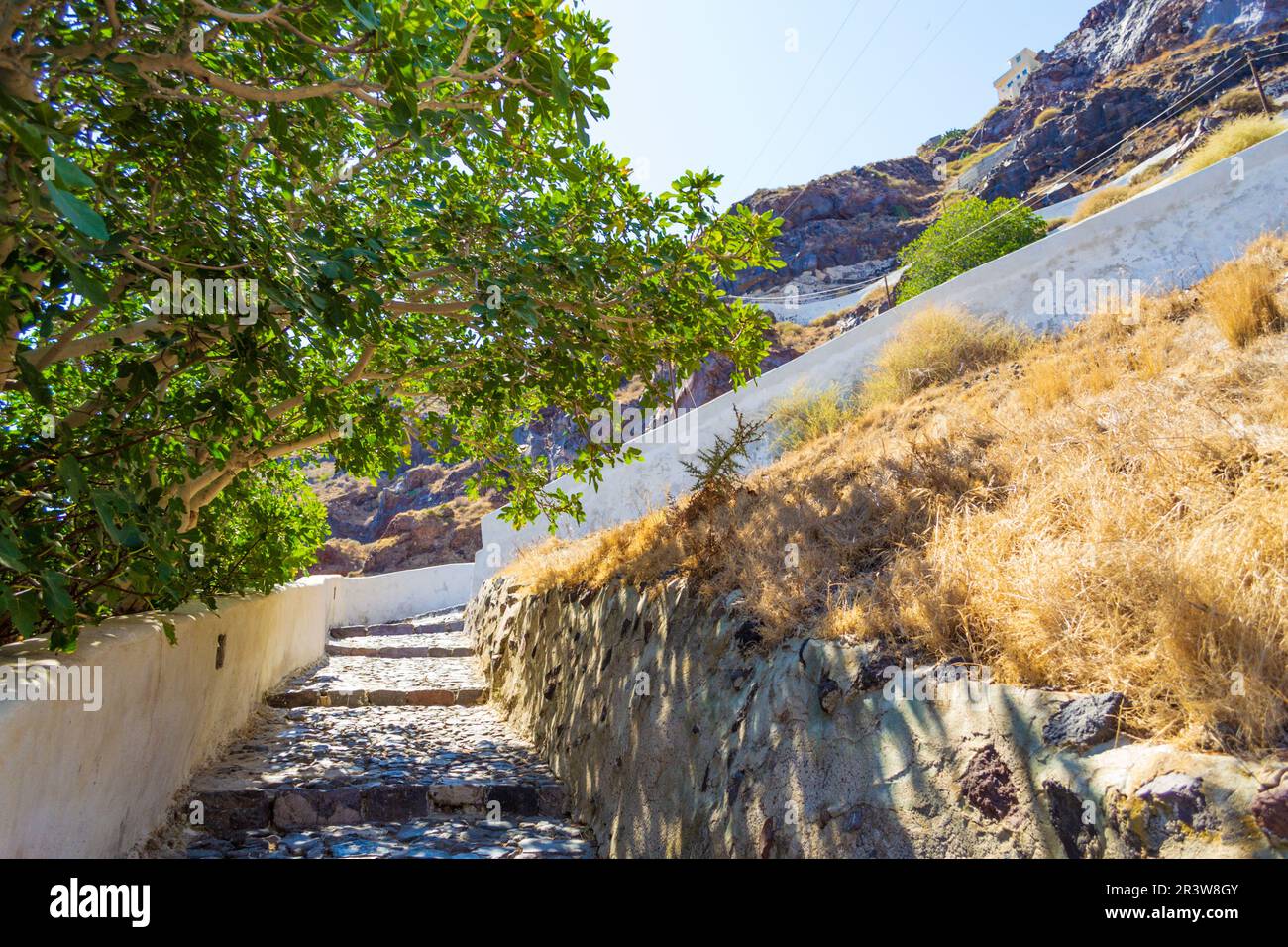 cliffside steps leading from fish restaurants on Korfos pebble beach ...