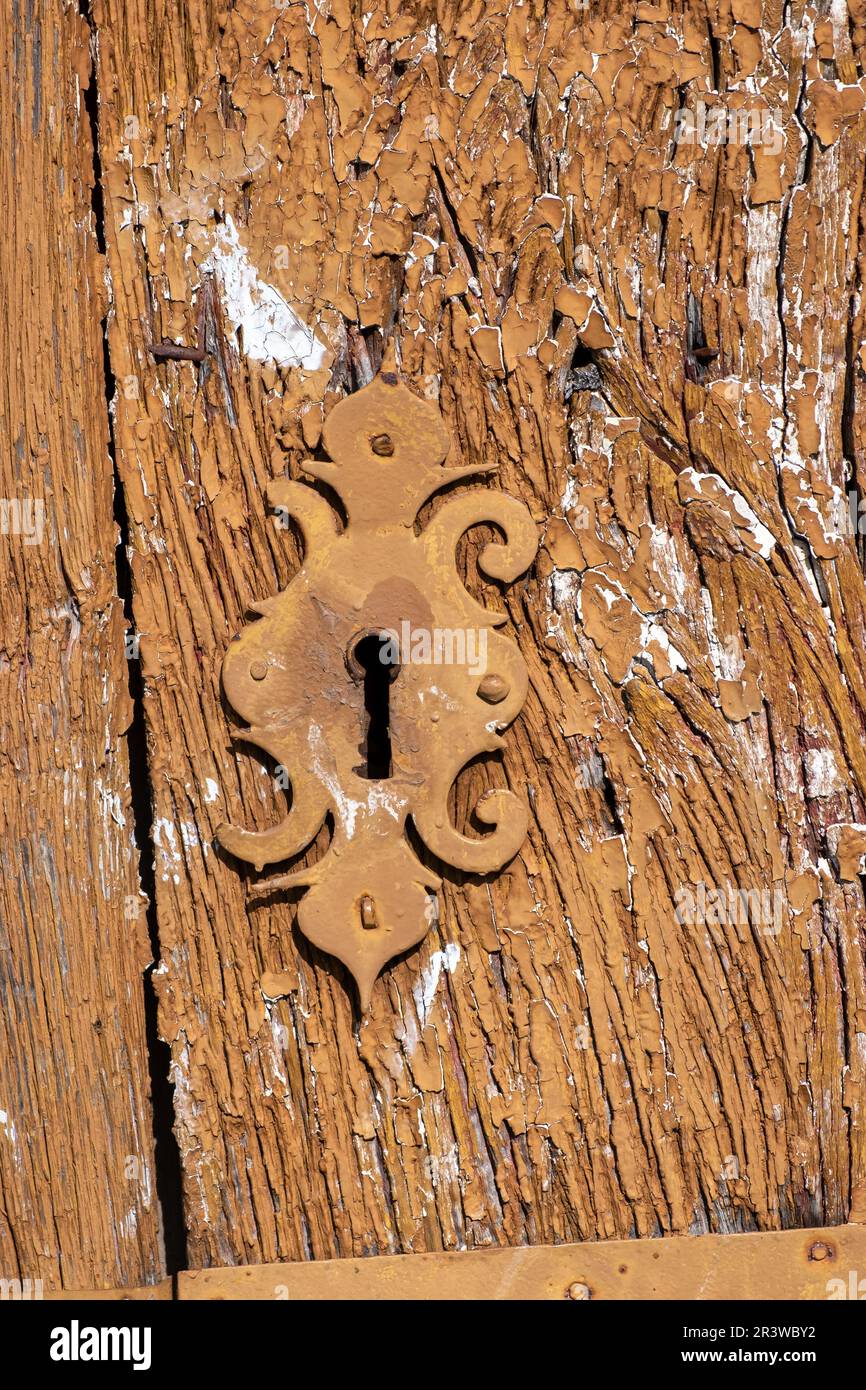 close-up view of an antique lock on a light brown painted wooden door ...