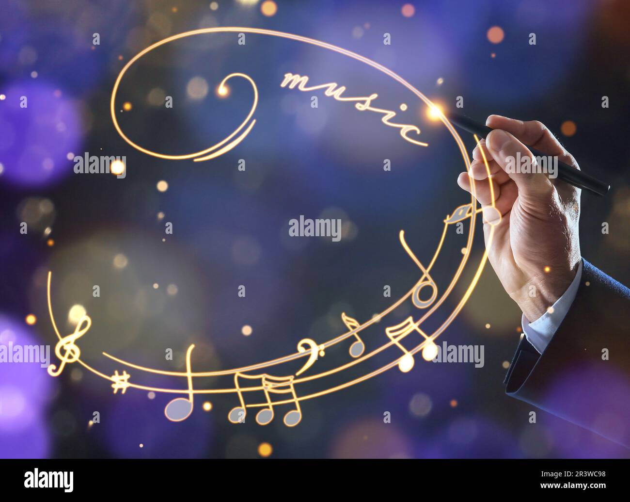 Man with pen drawing staff with music notes and symbols on color ...