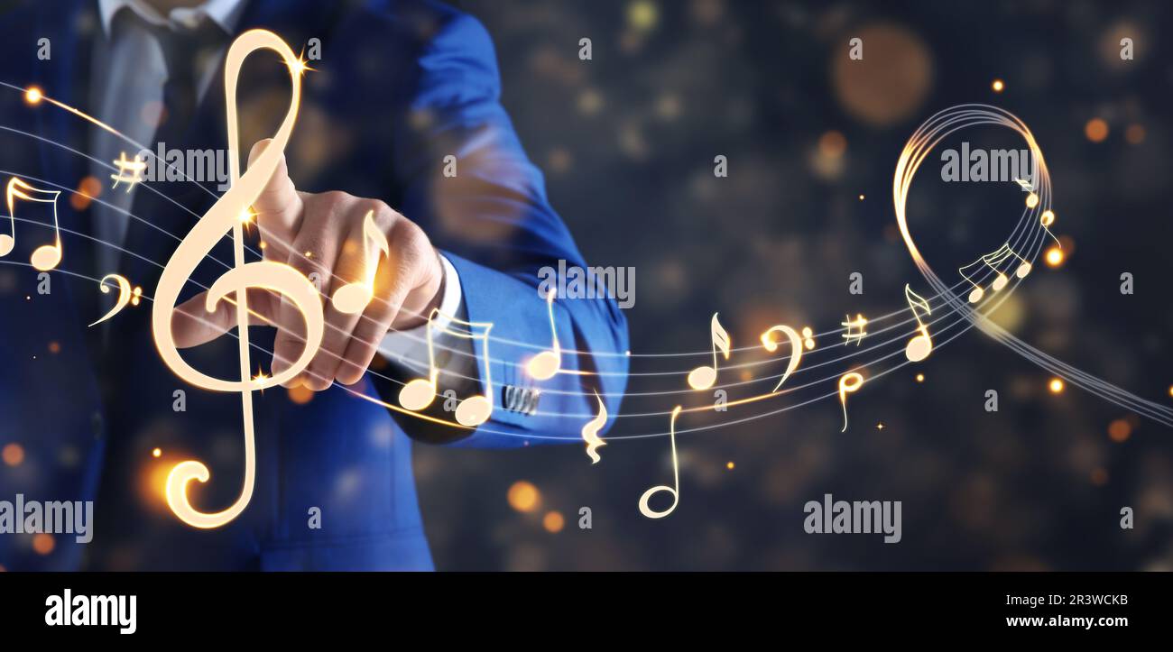Musician pointing at staff with music notes and symbols on color ...