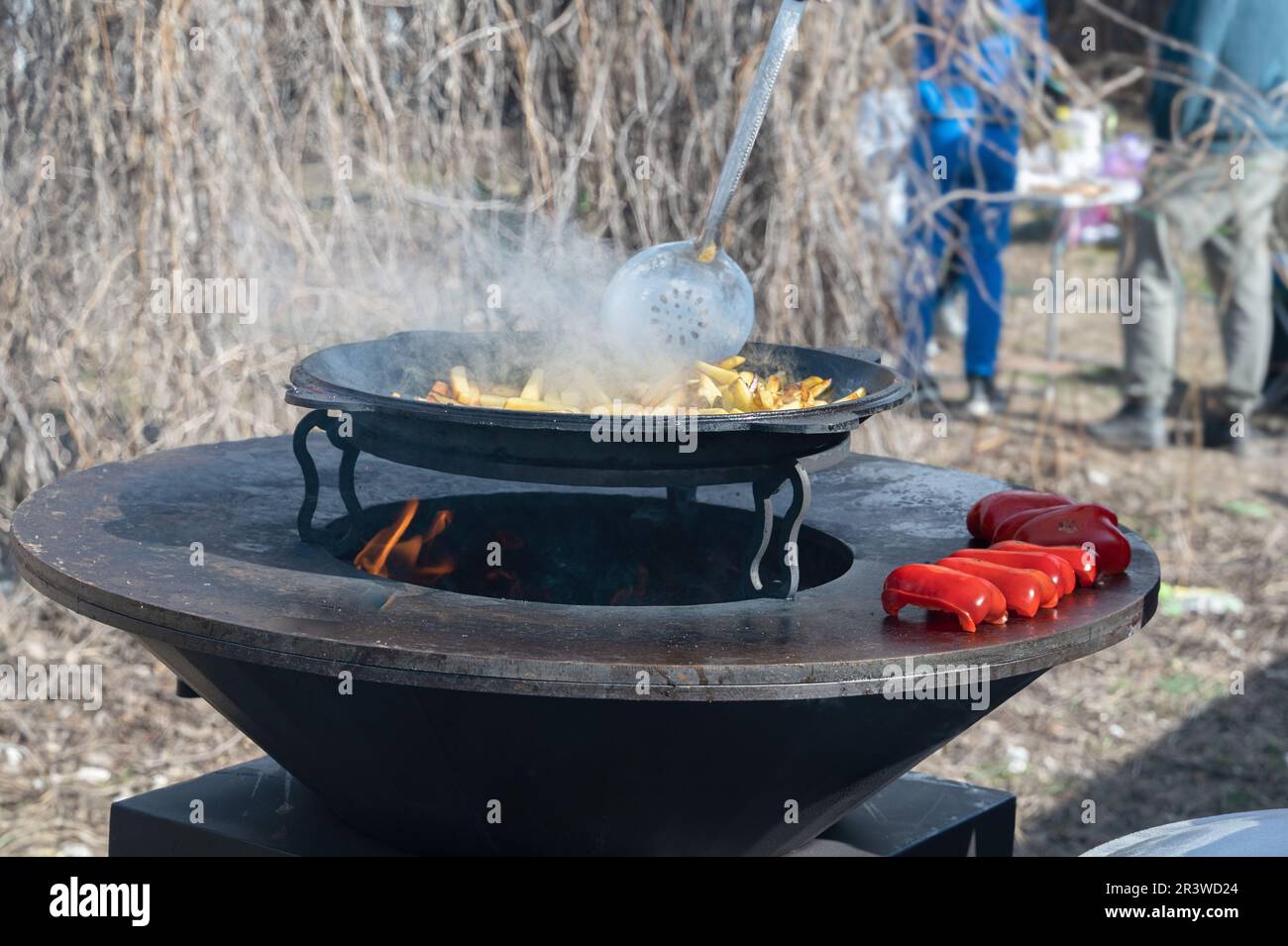 Vegetables are roasted on a round hearth. Round grill shaped like a ...