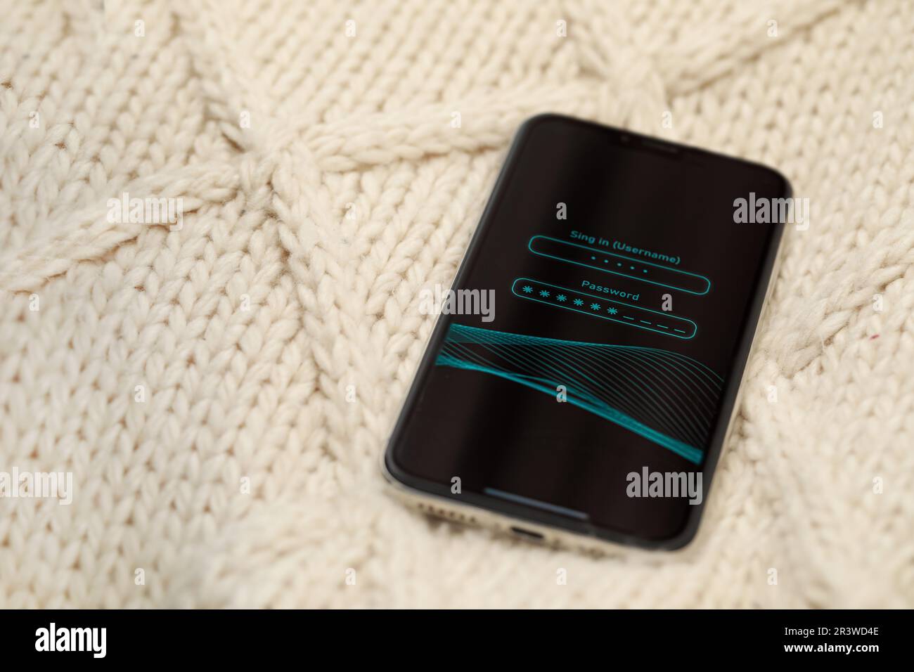 Smartphone with blocked screen on white knitted plaid, space for text ...