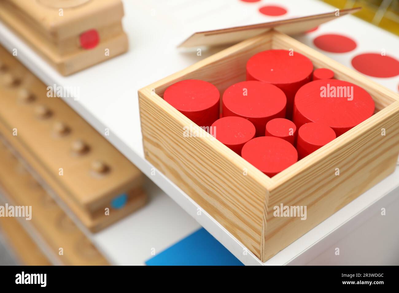 Set of wooden geometrical objects and other montessori toys on shelves ...