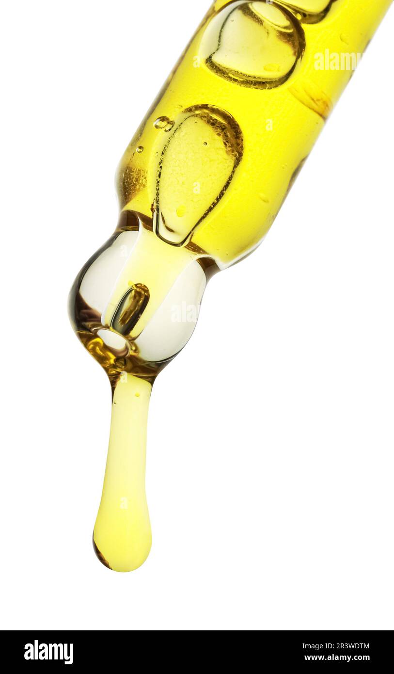 Dripping yellow facial serum from pipette on white background, closeup ...