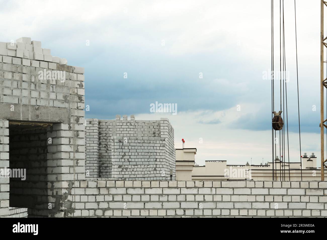 Construction site with tower crane near unfinished walls and buildings ...