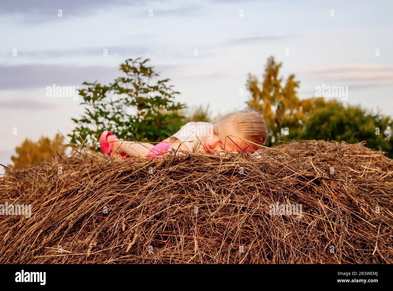 A little girl on the haystack in countryside Stock Photo - Alamy