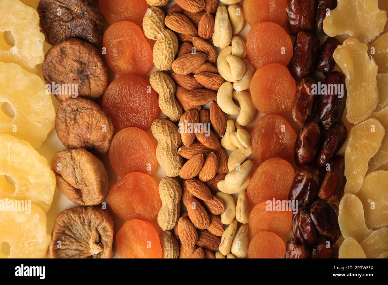 Different tasty nuts and dried fruits as background, top view Stock ...