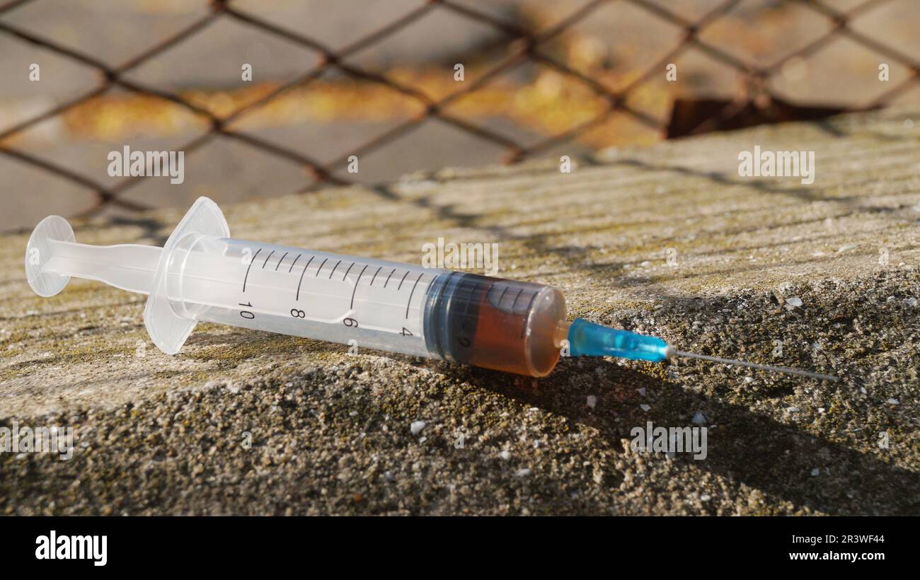 Syringe with hard drugs on stone surface outdoors, closeup Stock Photo ...