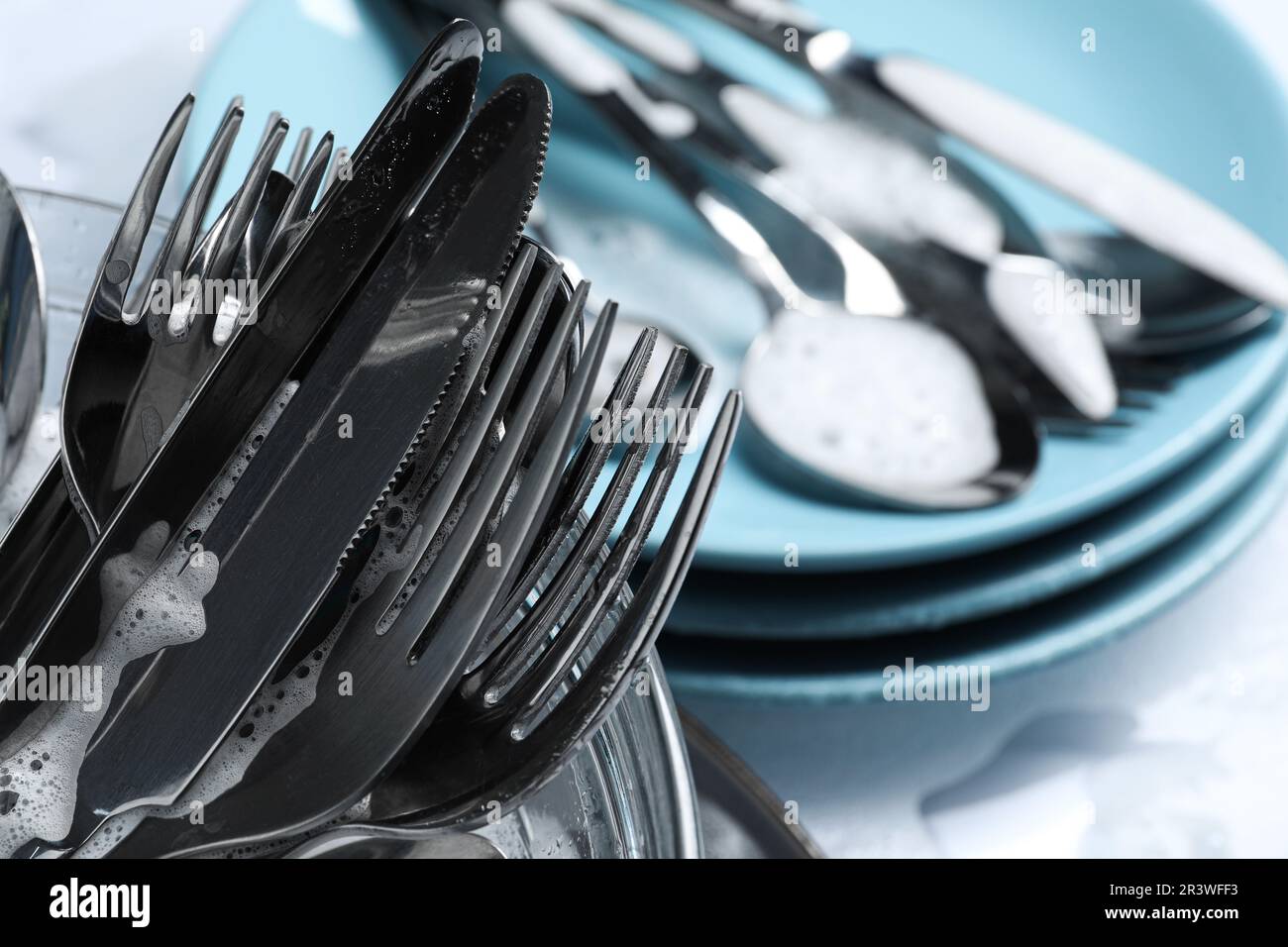 Glass bowl with silverware in foam, closeup Stock Photo - Alamy