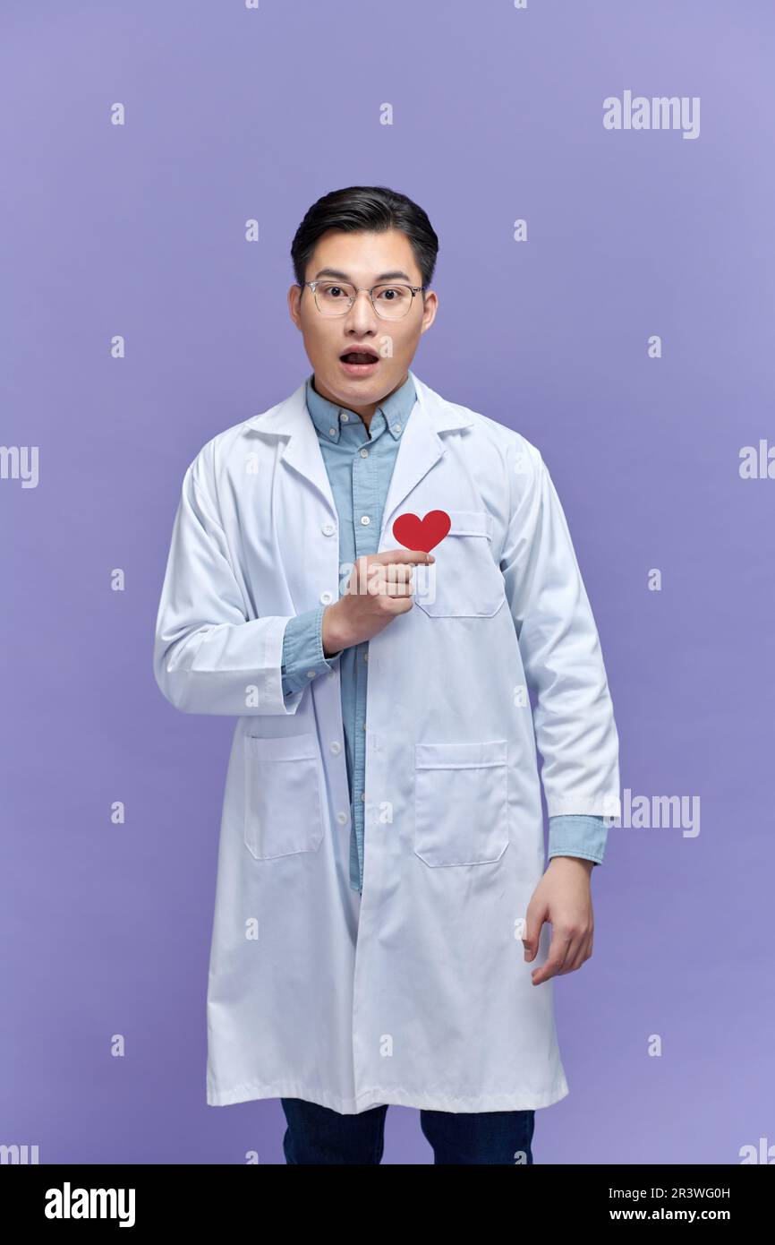 doctor man holding red heart scared and disbelief face with open mouth ...
