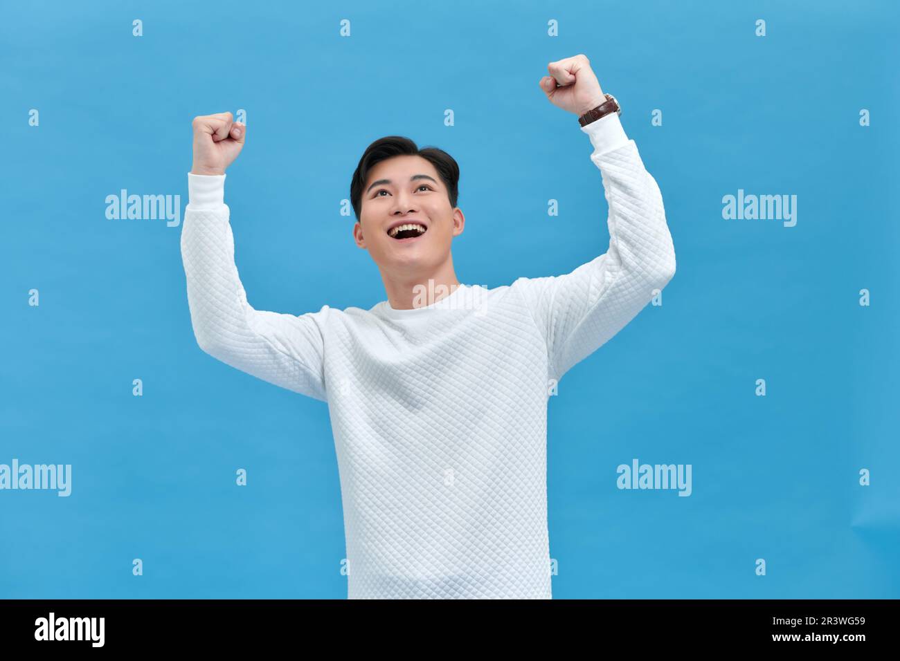 Portrait of overjoyed asian guy screaming with joy and clenched fists ...