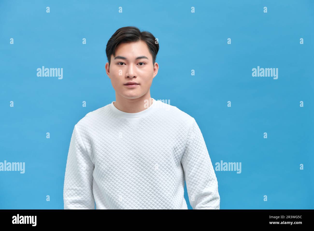 Portrait of good looking asian man over blue background Stock Photo - Alamy