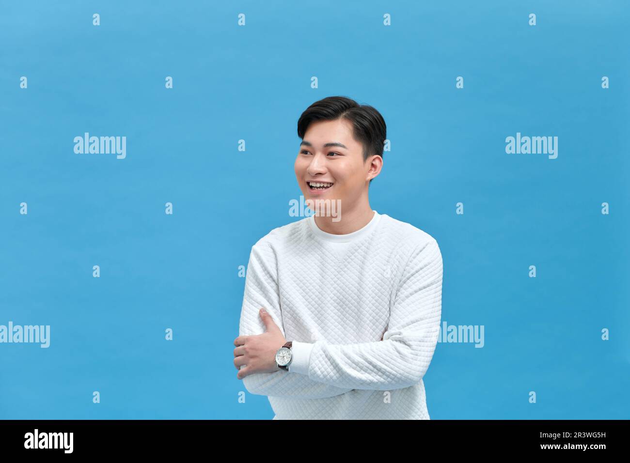 Portrait of happy Asian man in white t-shirt on isolated blue ...