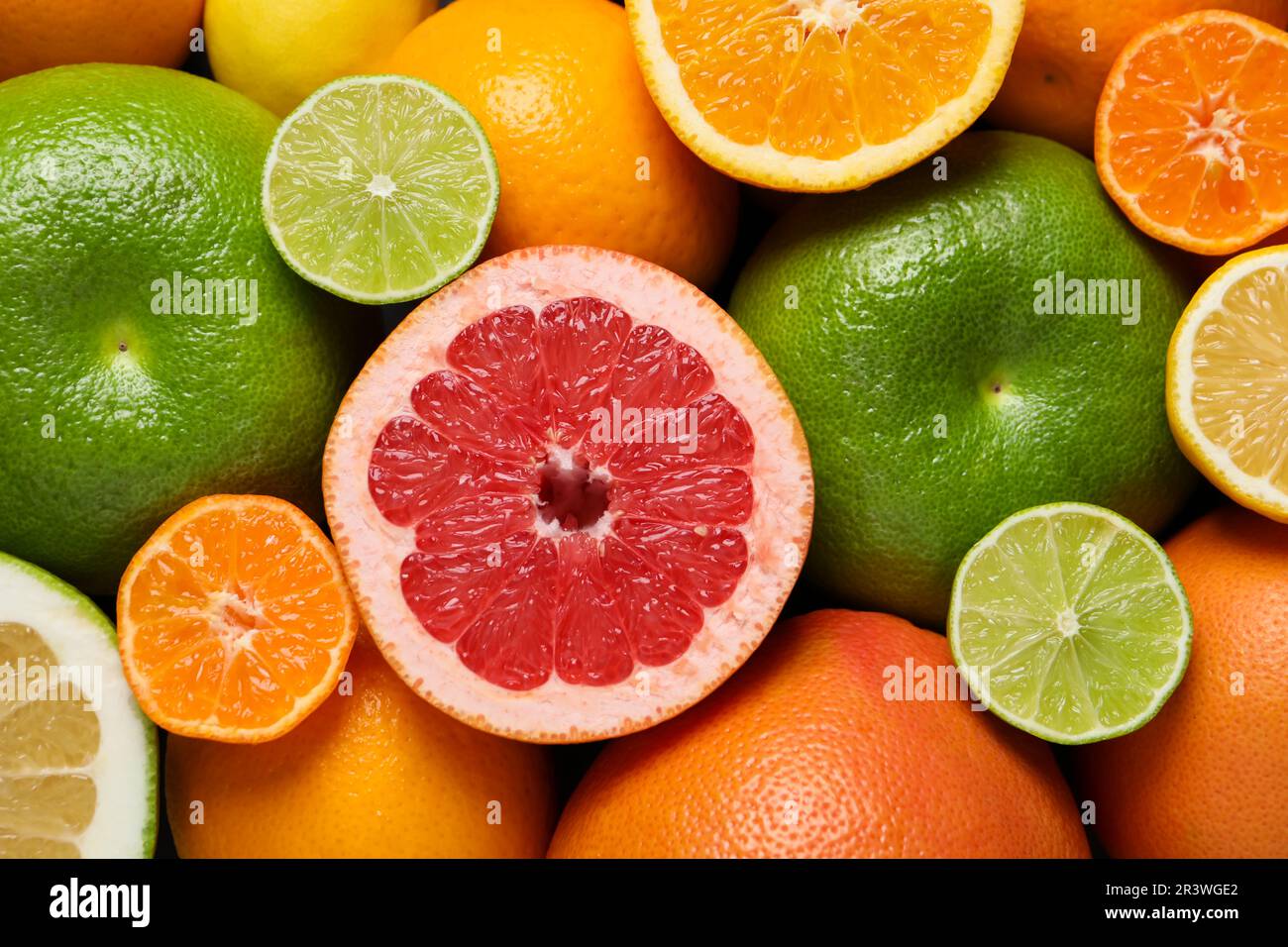 Different fresh whole and cut citrus fruits as background, top view ...