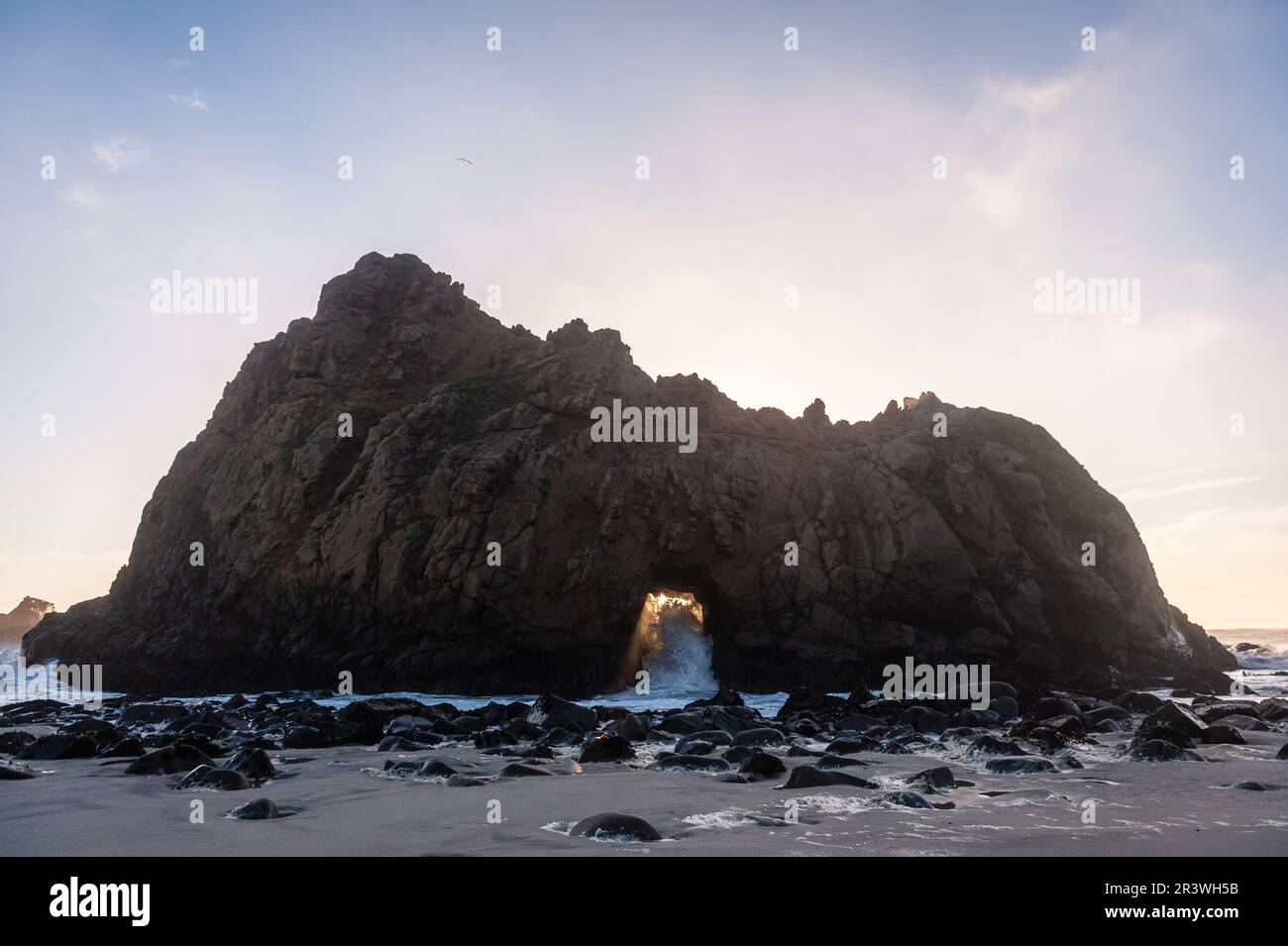 Wide-angle shot of the keyhole arch at Pfeiffer beach, California, whit ...