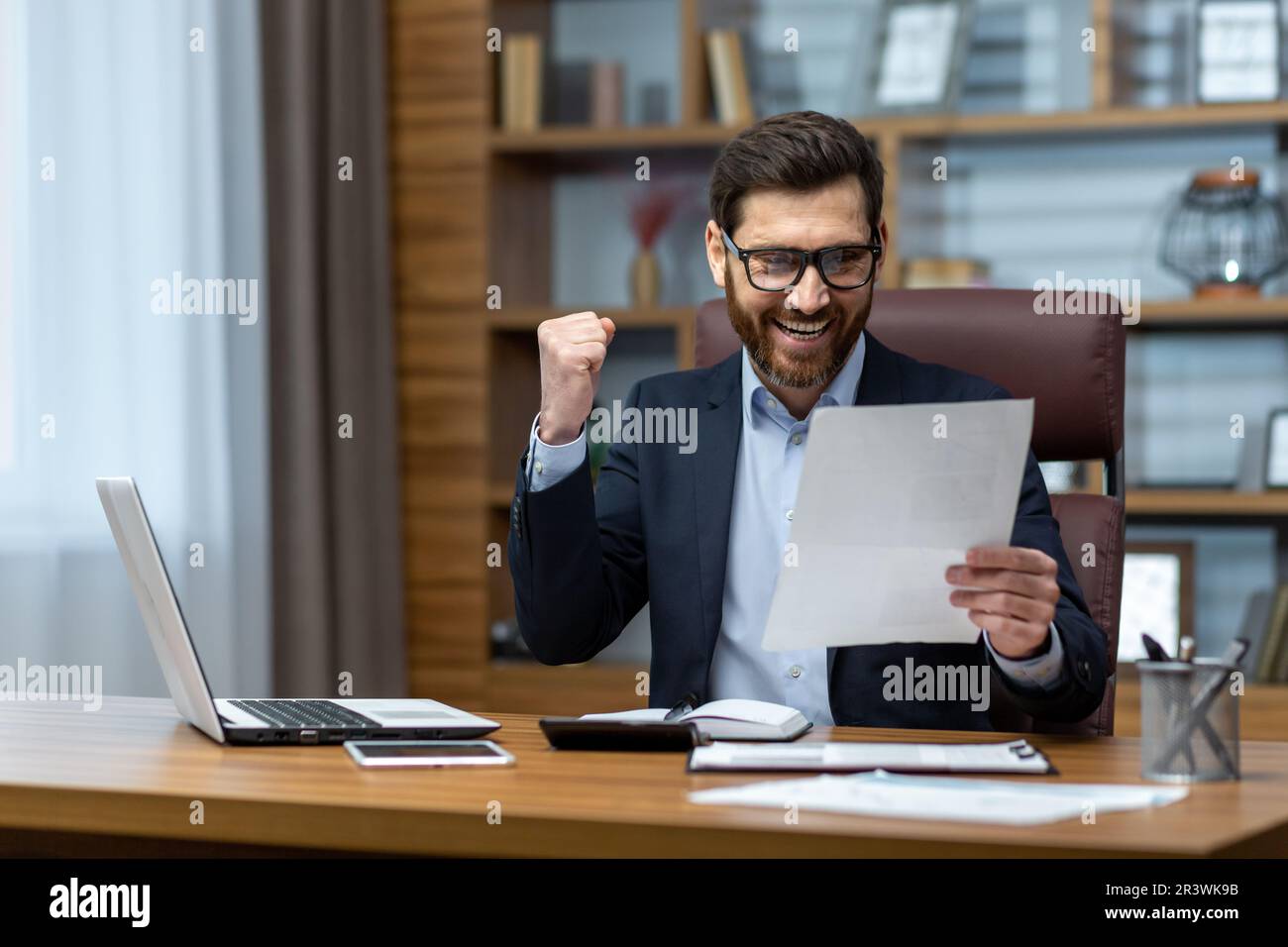 Successful businessman doing paperwork, boss with beard and glasses ...