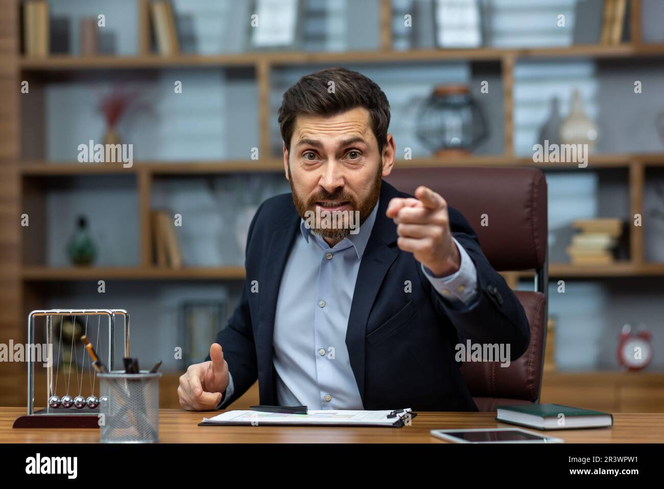 Portrait of an angry young businessman talking on a video call in the ...