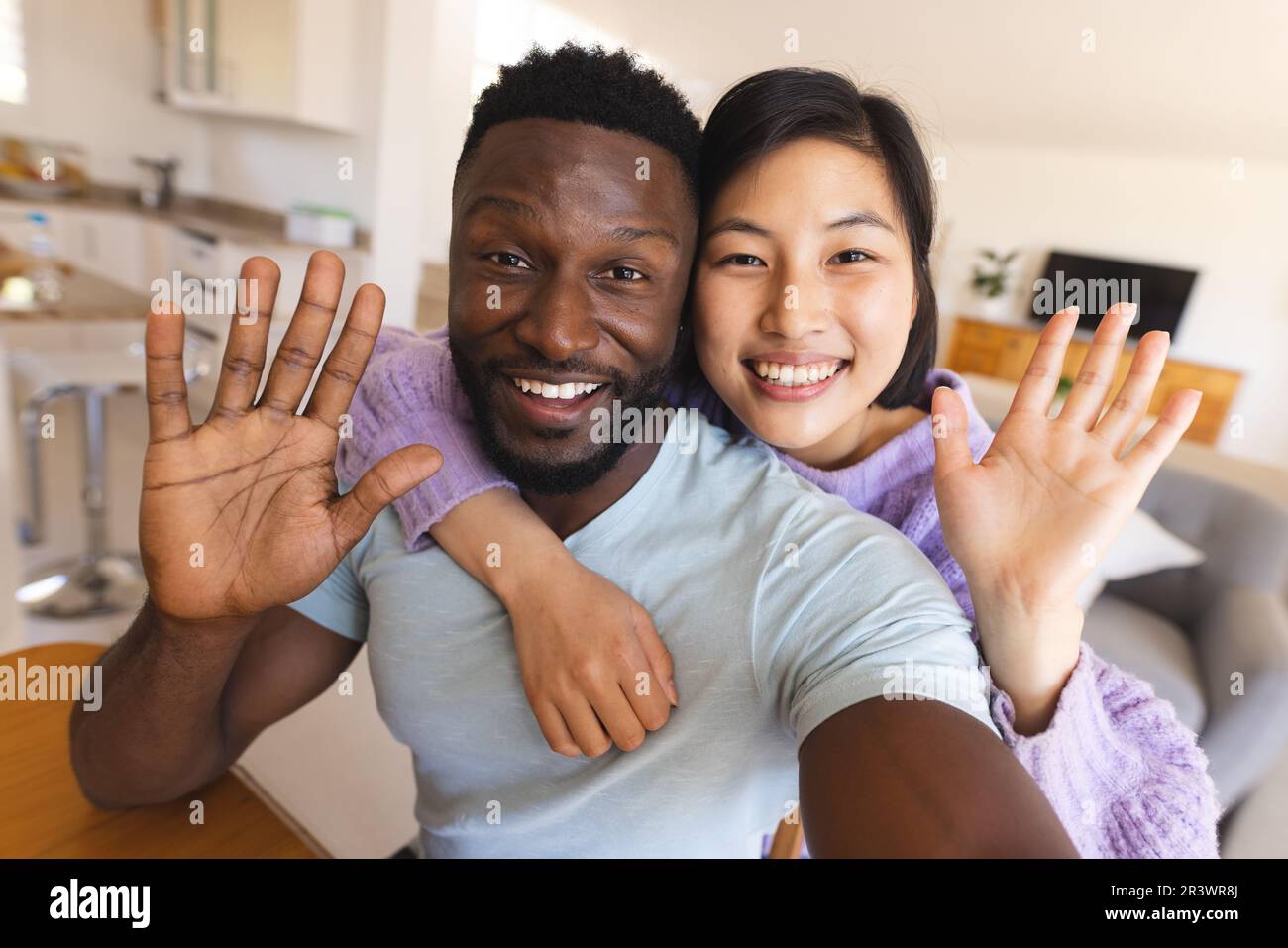 Happy diverse couple having video call and waving to camera Stock Photo ...