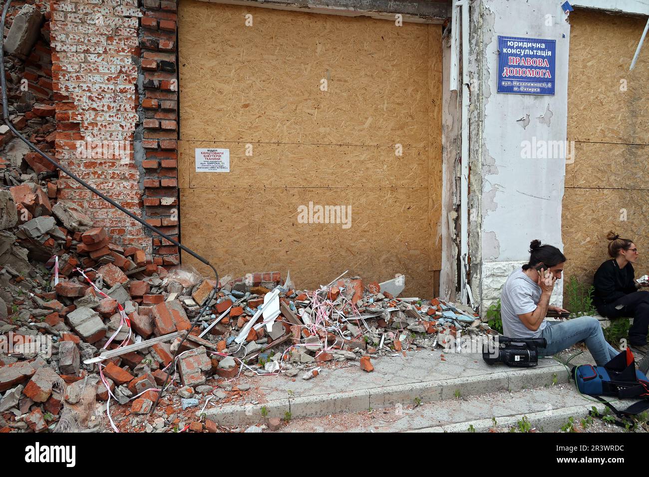 OKHTYRKA, UKRAINE - MAY 24, 2023 - Journalists sit near a pile of ...