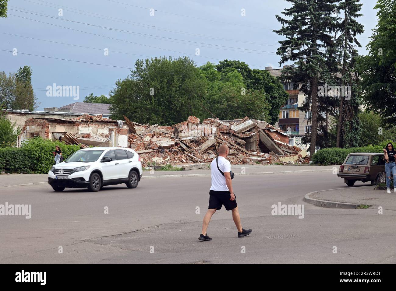 OKHTYRKA, UKRAINE - MAY 24, 2023 - A man crosses a street near a ...