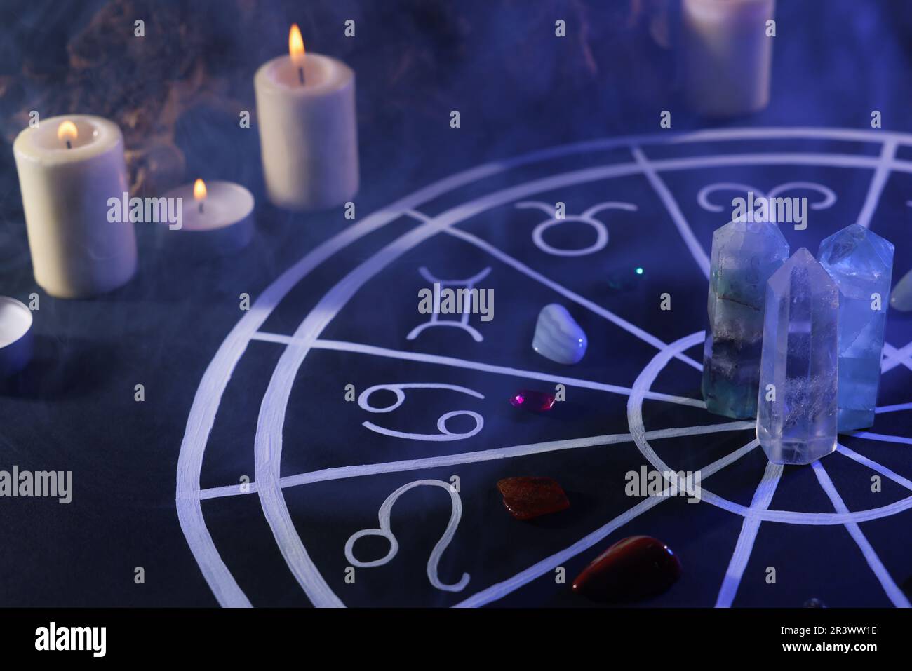 Natural stones for zodiac signs, drawn astrology chart and burning ...