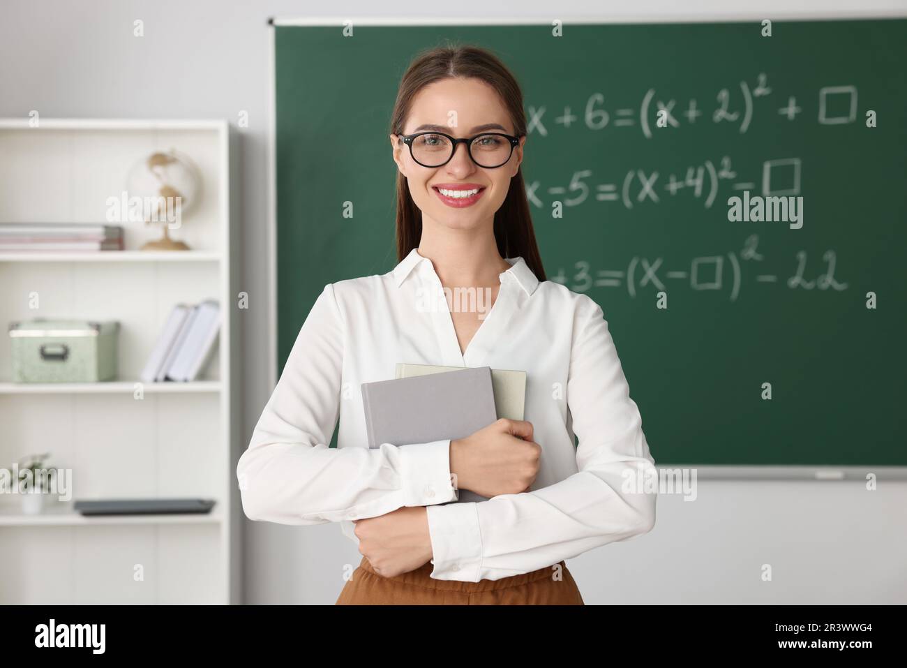 Portrait of young math’s teacher near chalkboard in classroom Stock ...