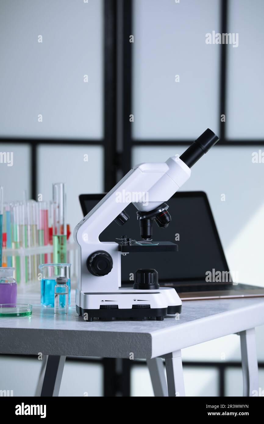 Modern microscope with glass slide on white table in laboratory Stock ...