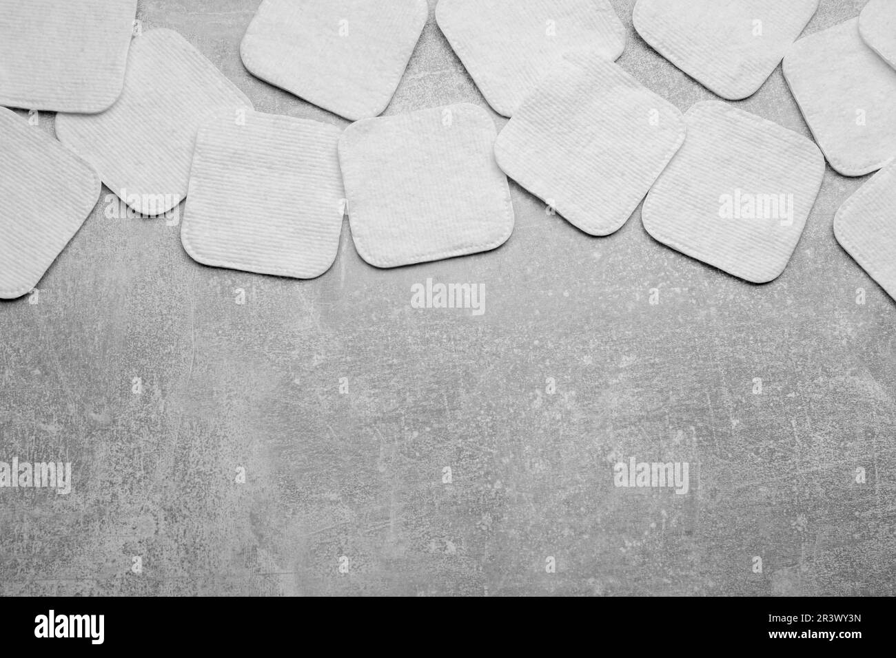 Many clean cotton pads on light grey background, flat lay. Space for ...