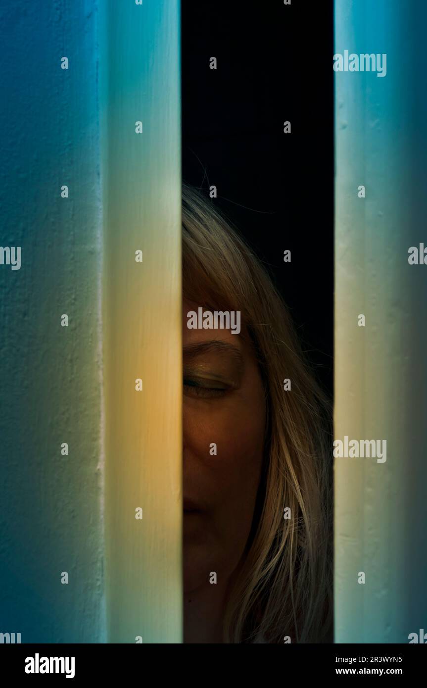 blond woman hidden behind a partially open door Stock Photo - Alamy
