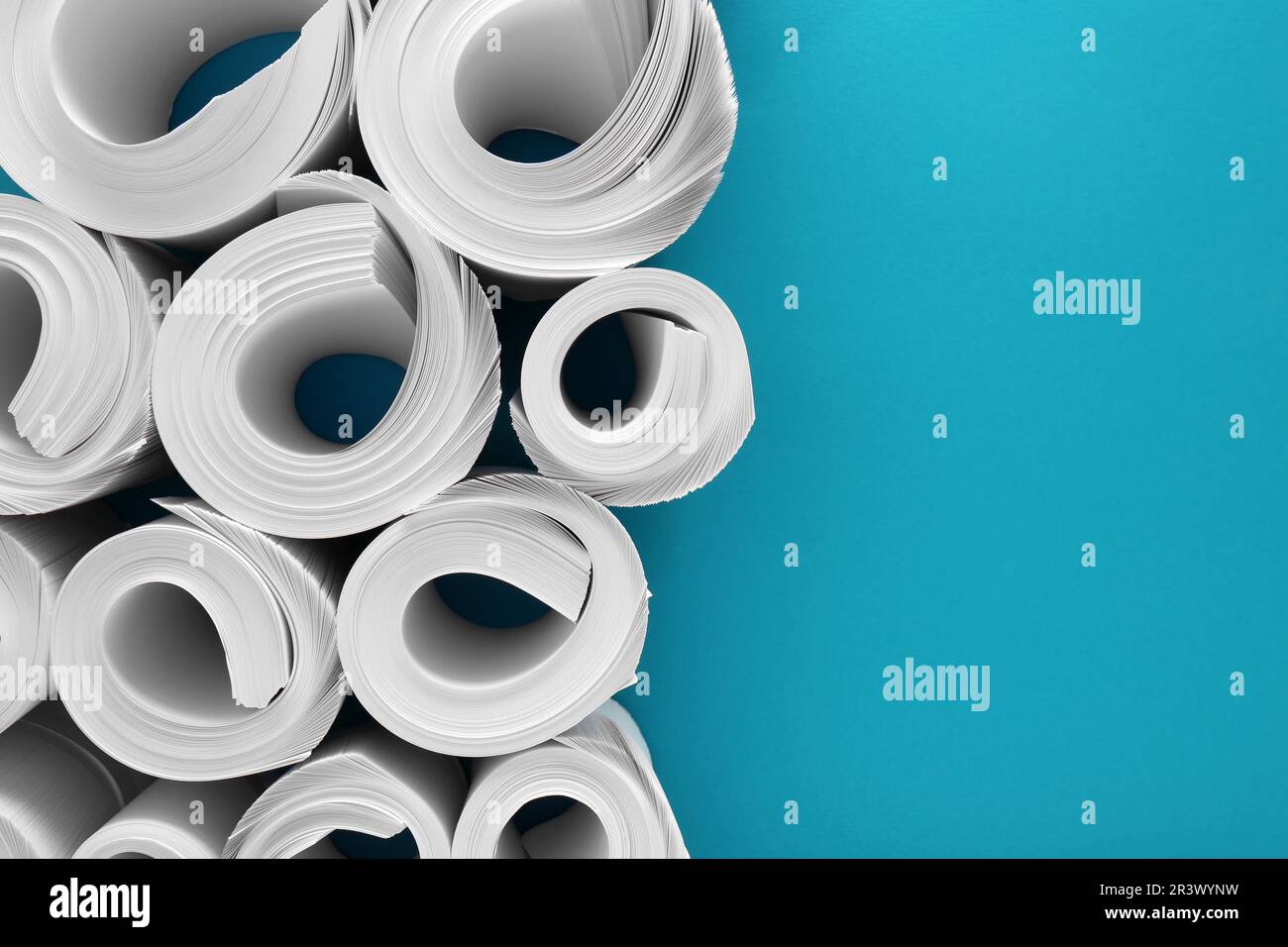 Blank white paper sheets on light blue background, flat lay. Space for ...