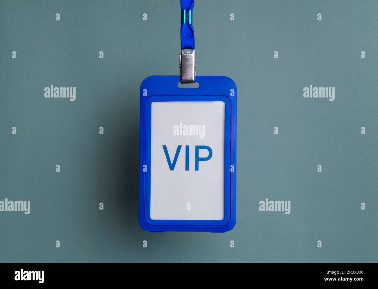 Blue plastic vip badge hanging on color background Stock Photo - Alamy