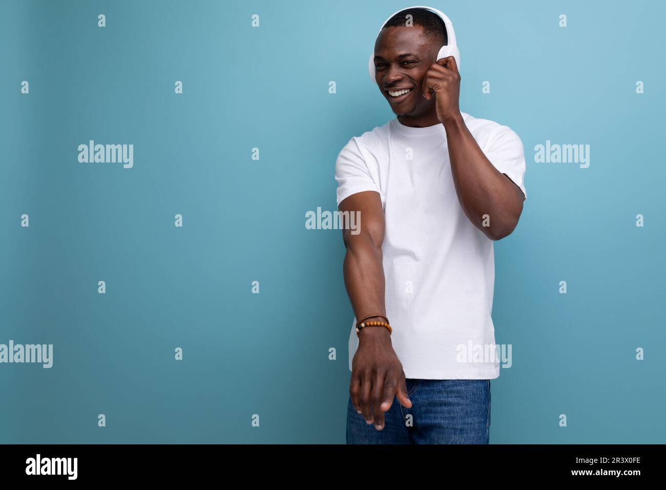 well-groomed handsome young african guy dancing to music in headphones ...