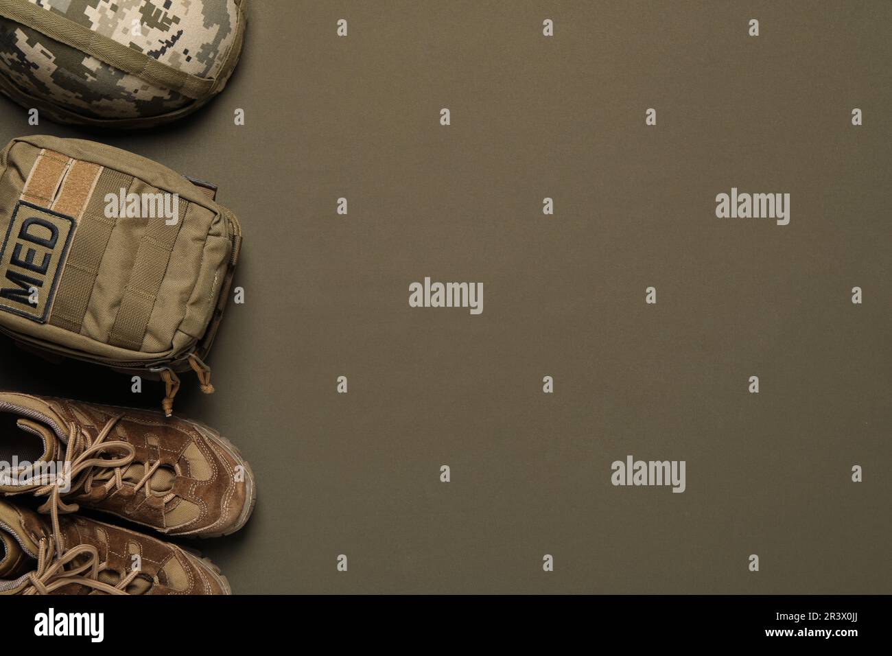 First aid kit, army boots and helmet on khaki background, flat lay ...