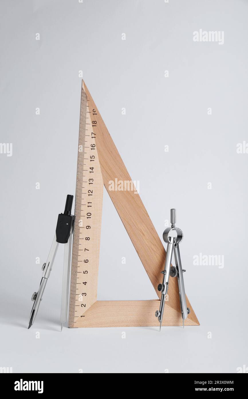 Triangle ruler and compasses on white background Stock Photo - Alamy