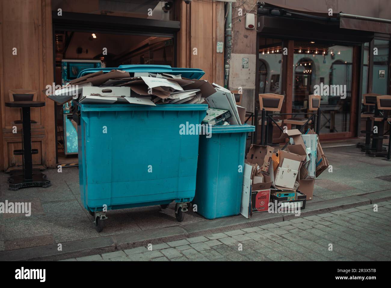 A large and small blue trash can near cafe on a city street. Sorting ...