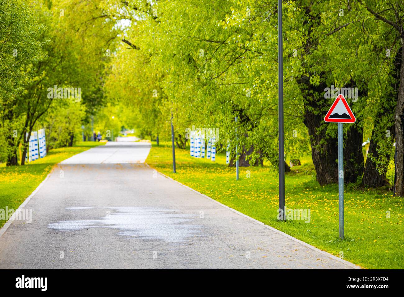 road sign in the park indicating a rough road. uneven road surface ...