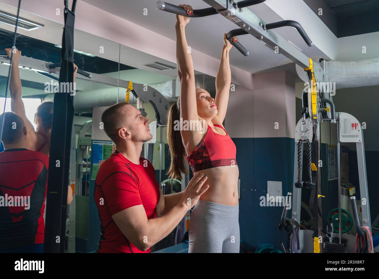 Personal trainer man working with young woman in modern gym Stock Photo ...