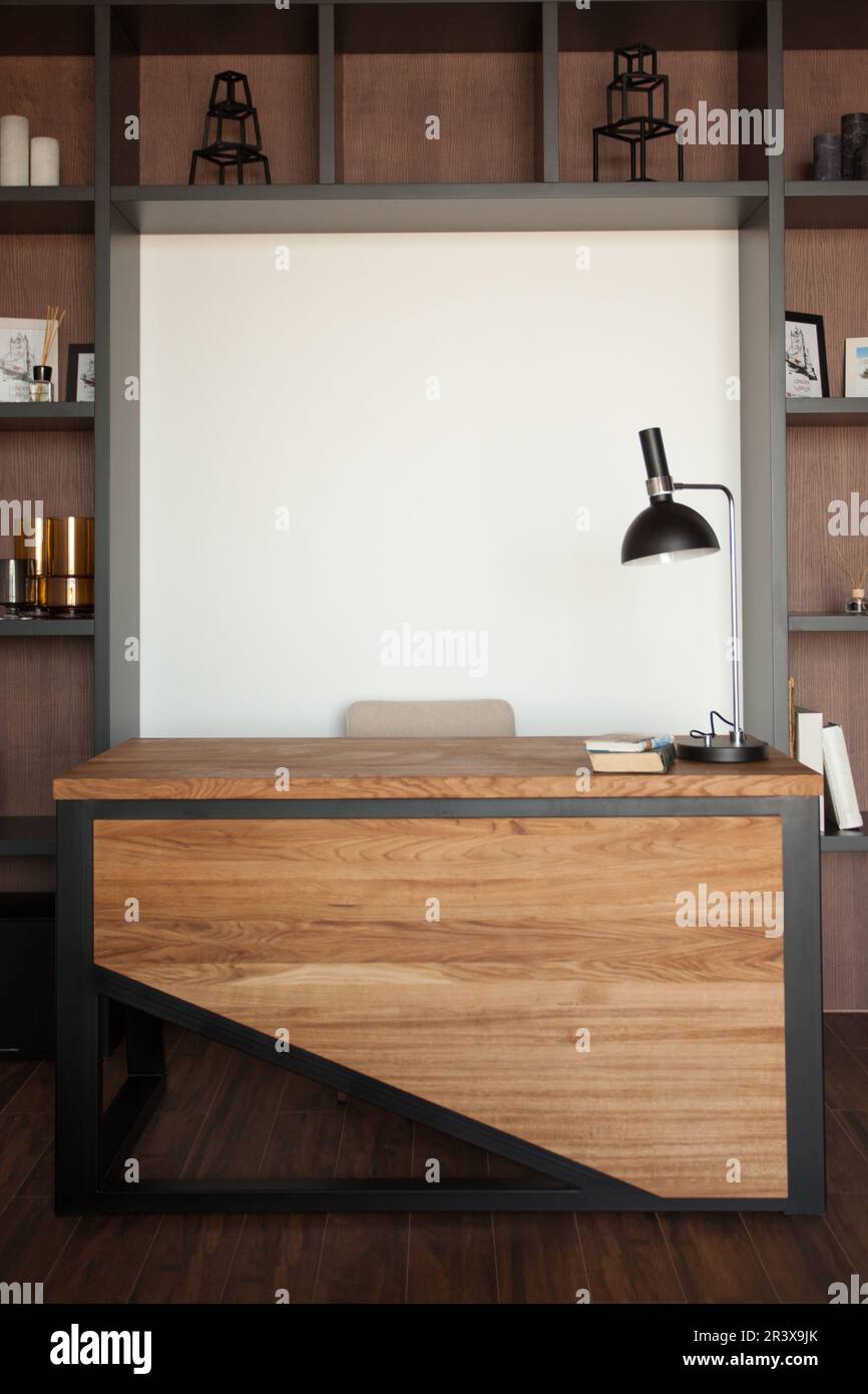 Wooden work desk with laptop and documents, books, modern interior of ...