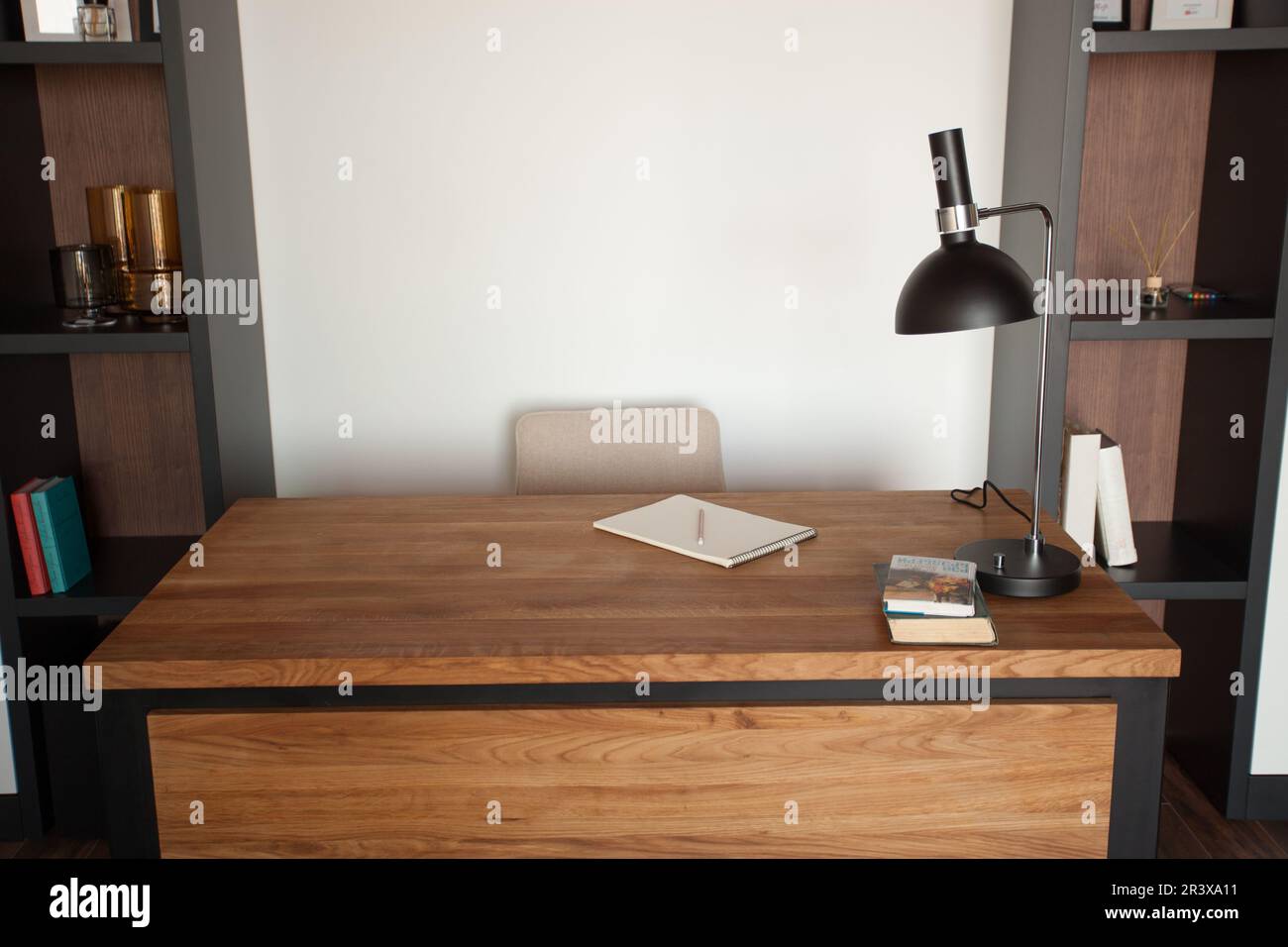 Wooden work desk with laptop and documents, books, modern interior of ...